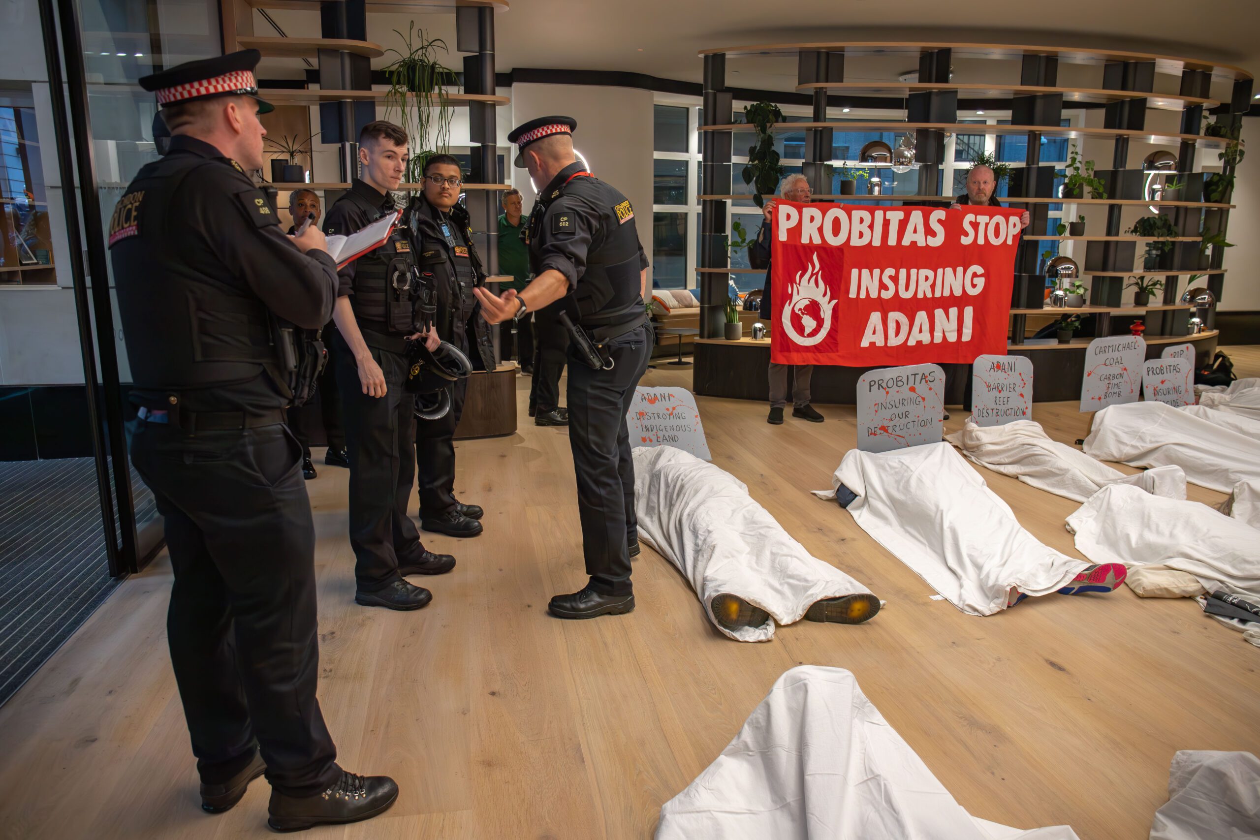 A coalition of protesters hold a die-in at the offices of Probitas in ...